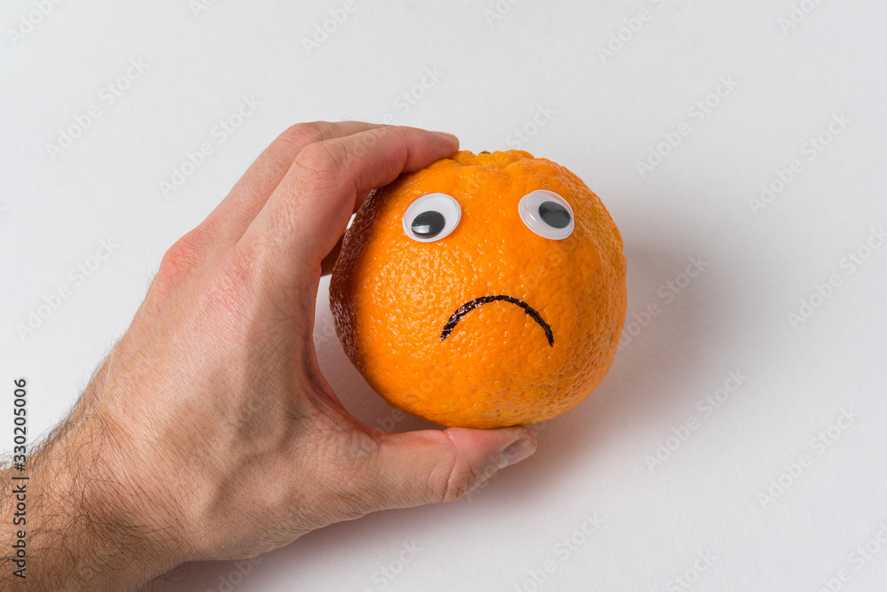Orange fruit character. Orange with eyes and sad smile in man hand ...