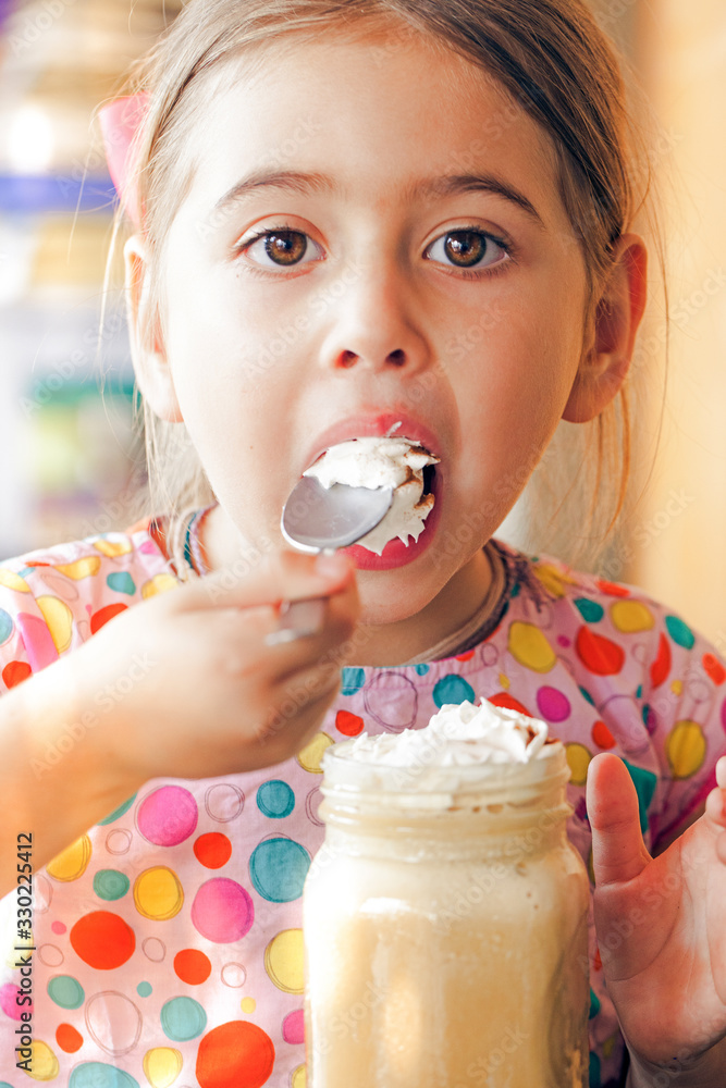 cute little girl eating whipped cream Stock Photo | Adobe Stock