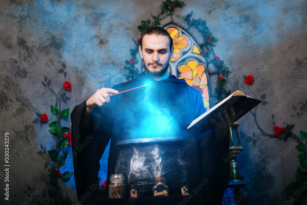 The mage is cooking a potion. A male wizard in a black mantle with a ...