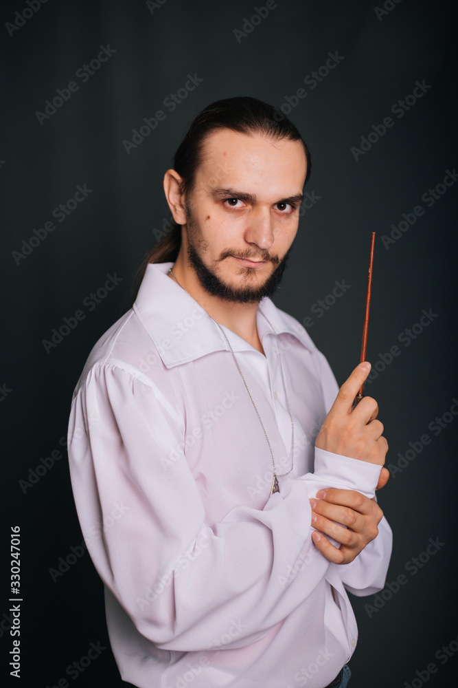 Wizard man in a white shirt conjures. A guy with long hair and a beard ...