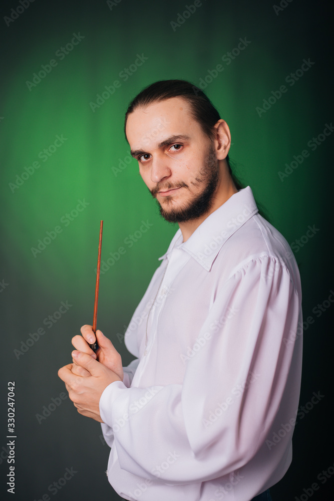 Wizard man in a white shirt conjures. A guy with long hair and a beard ...