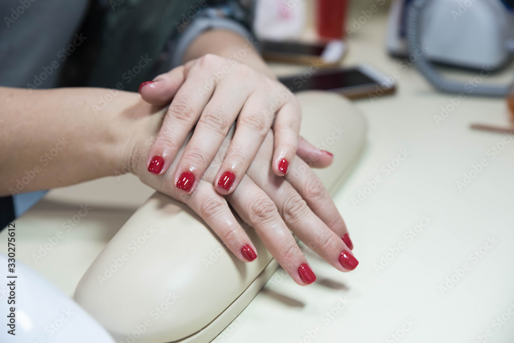 Nail care and manicure. Closeup woman hands in a beauty salon receiving ...