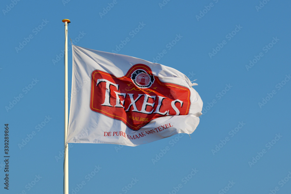 Flag with logo of Dutch Texel beer brand blowing in the wind in front ...
