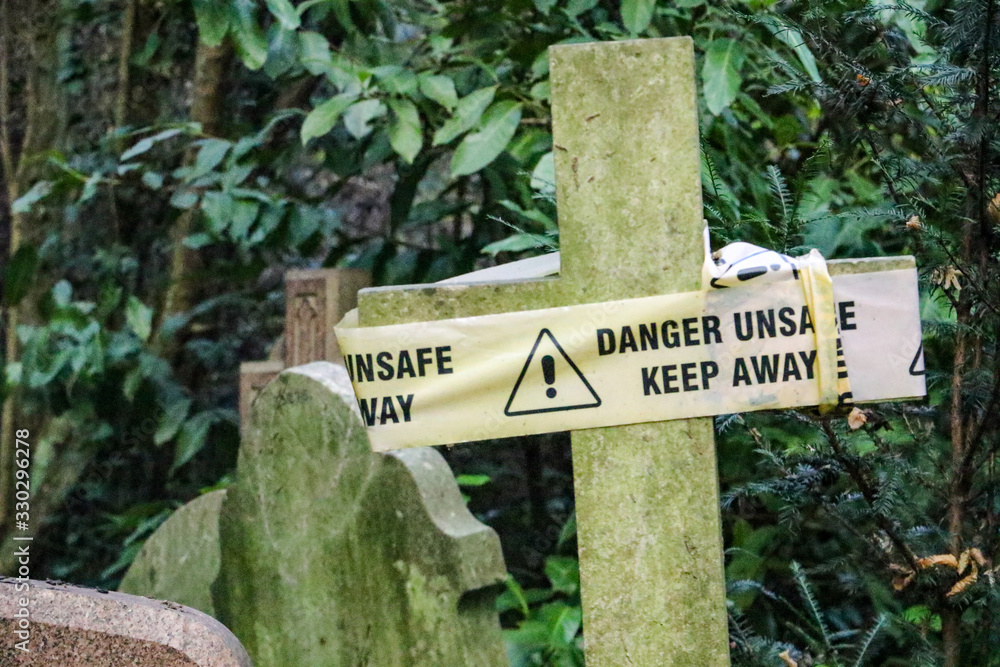 Damaged Victorian stone cross in Highgate Cemetery with danger unsafe ...