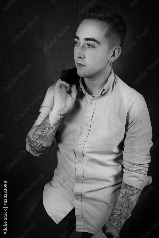 sesion de interior a un chico joven elegante y trajeado con tatuajes en ...