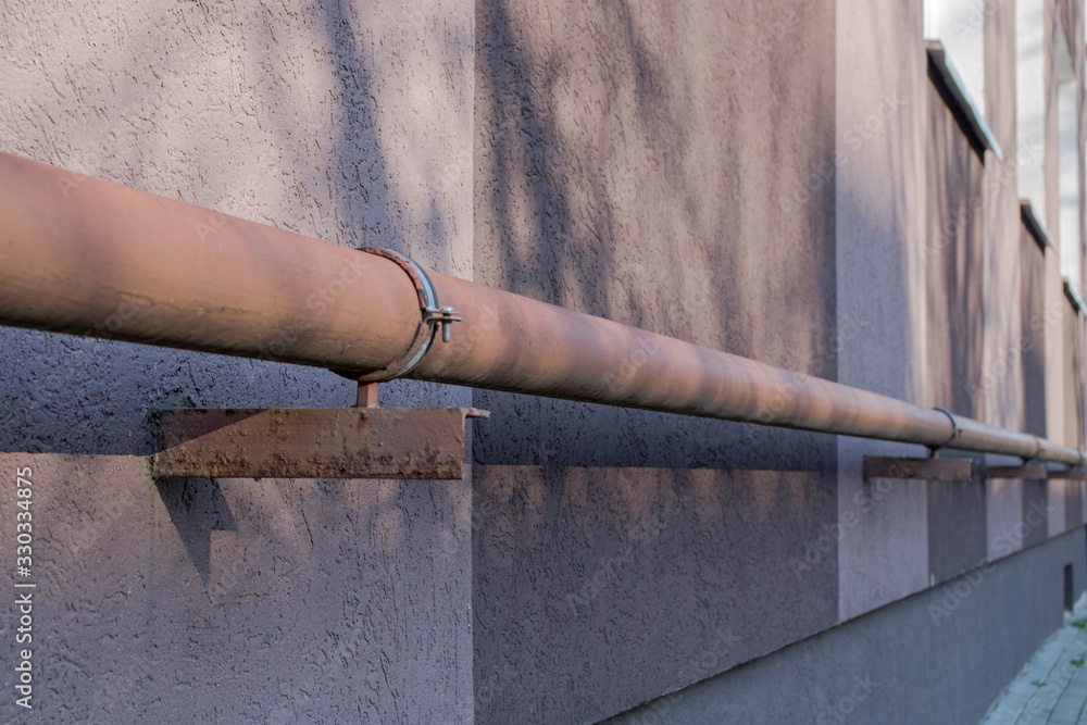 Foto de Brown metal pipe running along windows row of lower floor ...