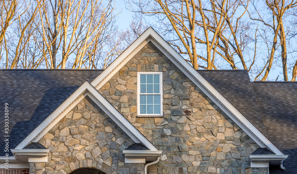 Classic double gable covered with stone veneer, white frame double sash ...