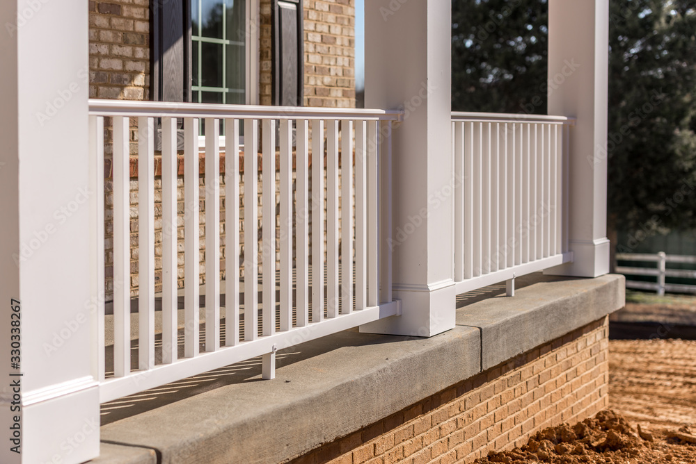 Covered porch with brick siding, pre cut and pre mitered white columns ...