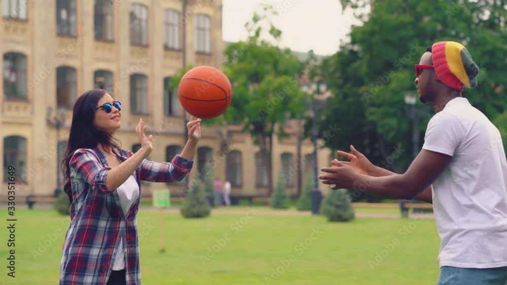 Handsome guy and girl throw a ball. Afroamerican guy and caucasian girl ...