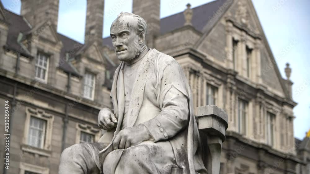 Statue of George Salmon in Trinity college, Dublin Ireland. Blue sky ...