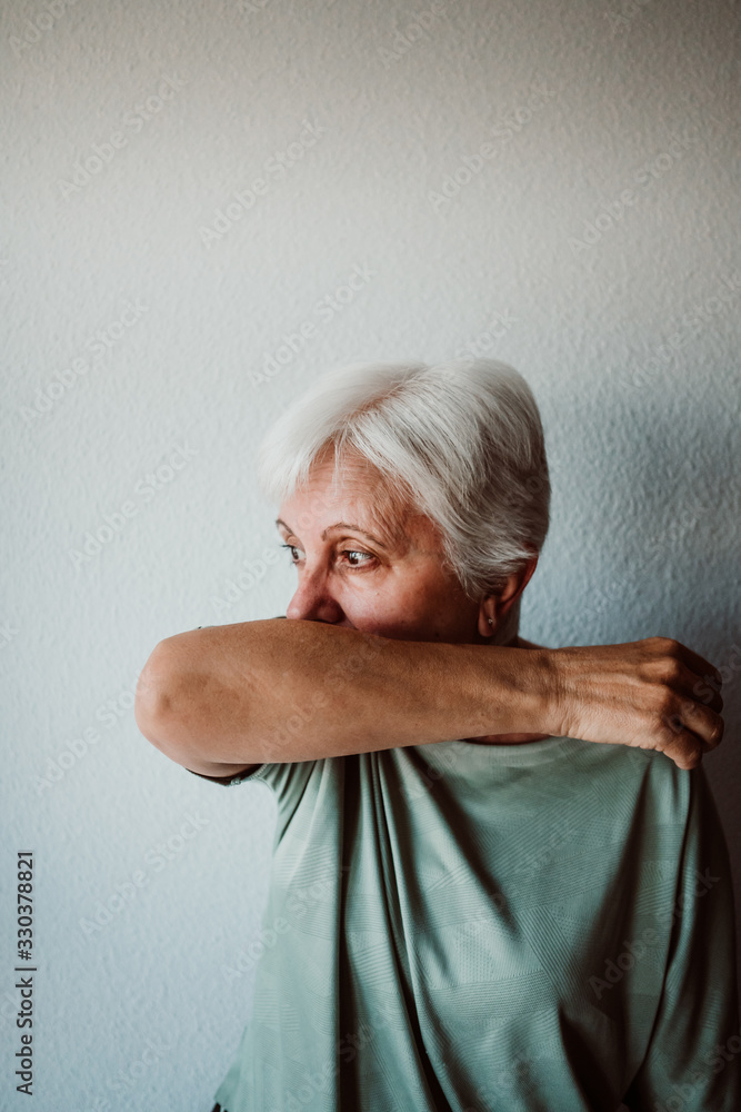 Senior woman coughing into elbow Stock Photo | Adobe Stock
