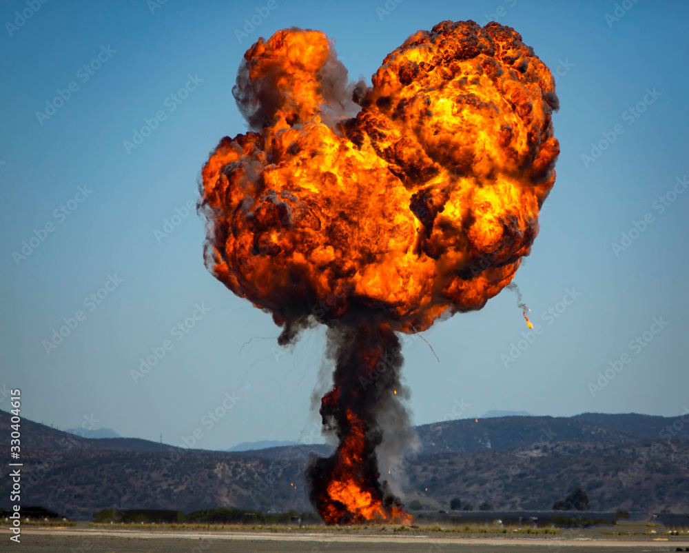 Heart shapped ball of fire and column of smoke from munitions explosion ...