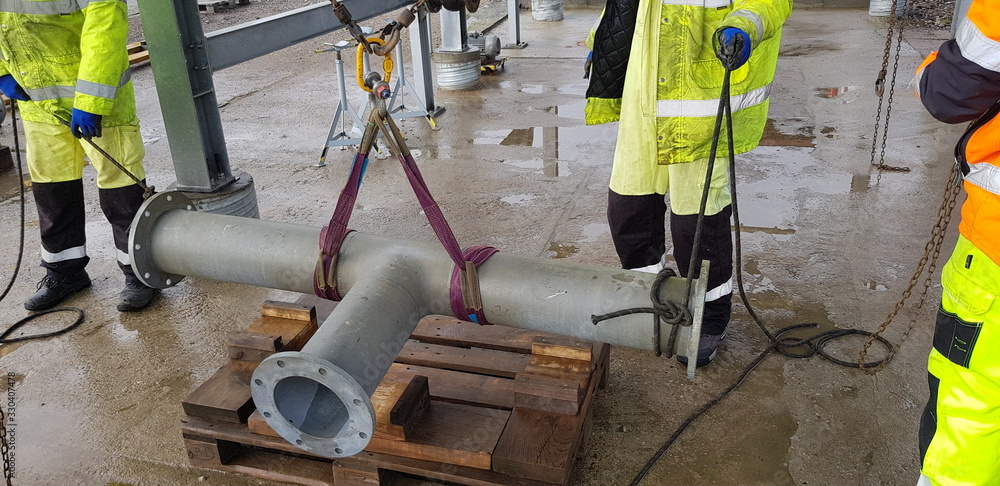 riggers move the pipe using two chain blocks Stock Photo | Adobe Stock