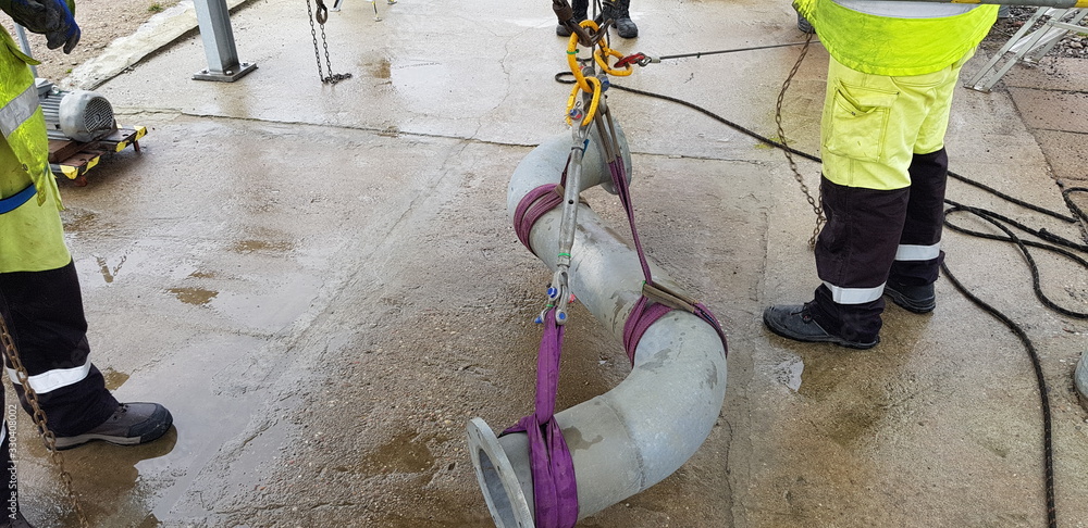 riggers move the pipe using two chain blocks Stock Photo | Adobe Stock