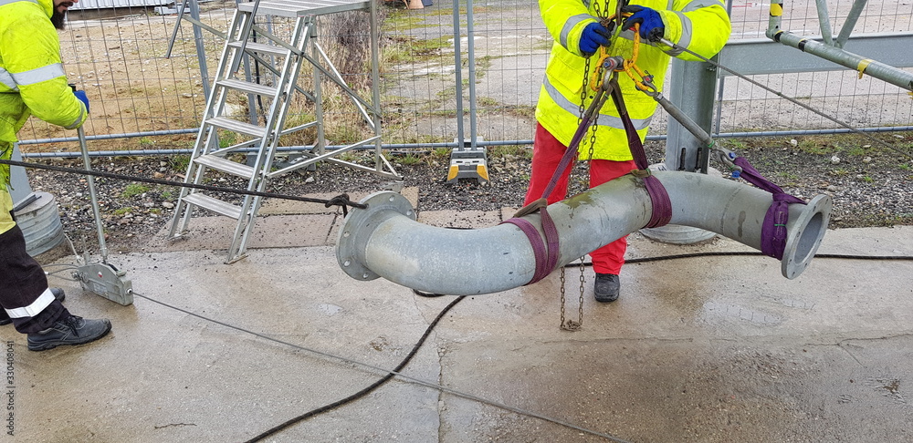 riggers move the pipe using two chain blocks Stock Photo | Adobe Stock