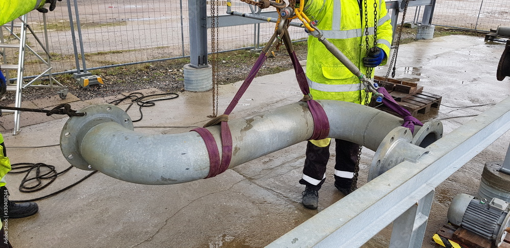 riggers move the pipe using two chain blocks Stock Photo | Adobe Stock