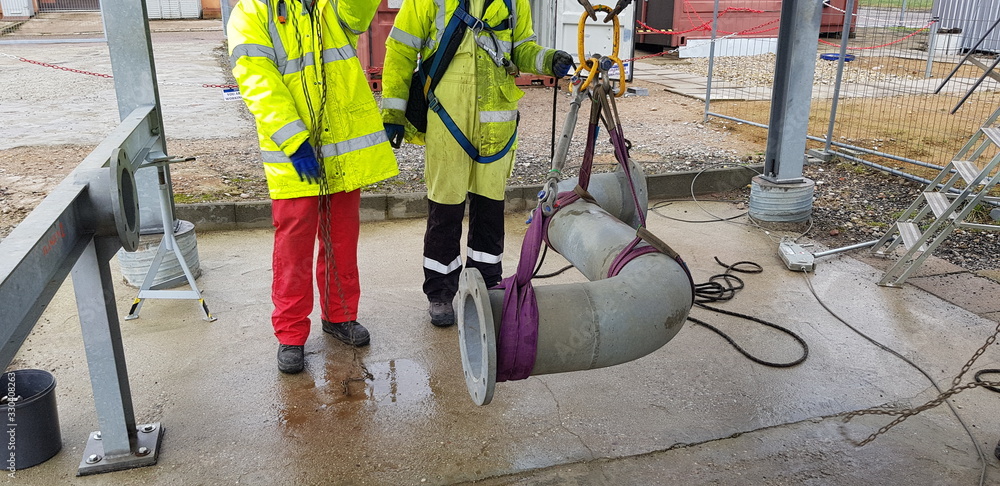 riggers move the pipe using two chain blocks Stock Photo | Adobe Stock
