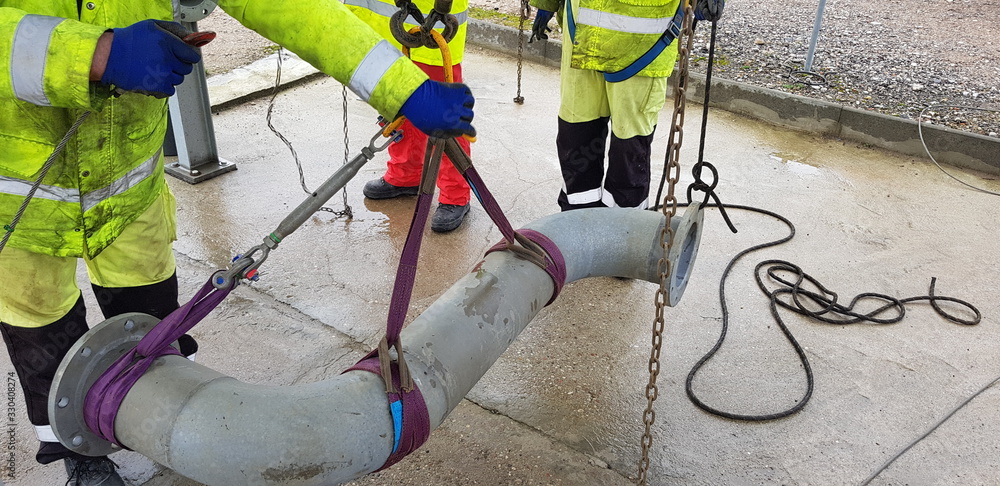 riggers move the pipe using two chain blocks Stock Photo | Adobe Stock