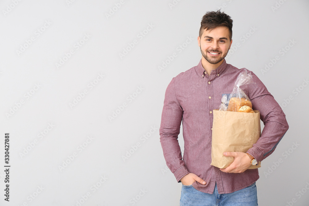 Young man with fresh products from market on light background Stock ...