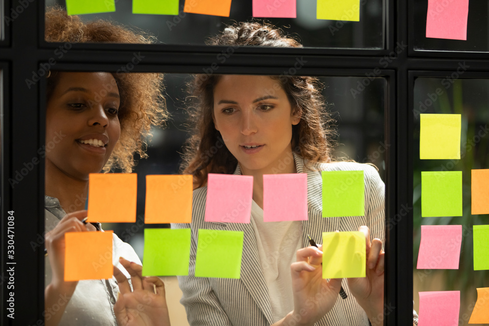 Diverse colleagues discussing notes on sticky papers close up, managers ...