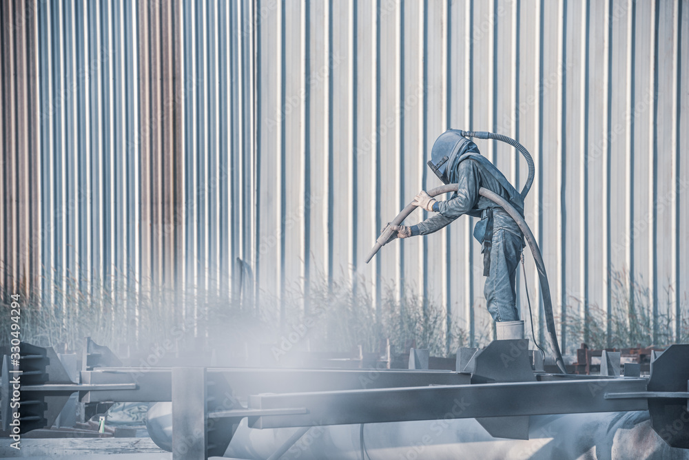 Sand blasting process, Industial worker using sand blasting process ...