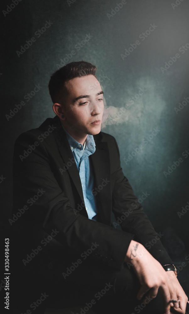 sesion de interior a un chico joven elegante y trajeado con tatuajes en ...