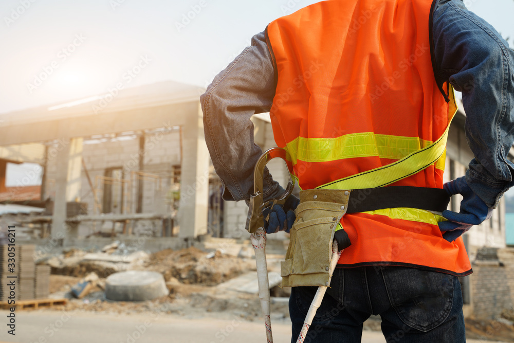 Construction worker wearing safety harness and safety line working at ...