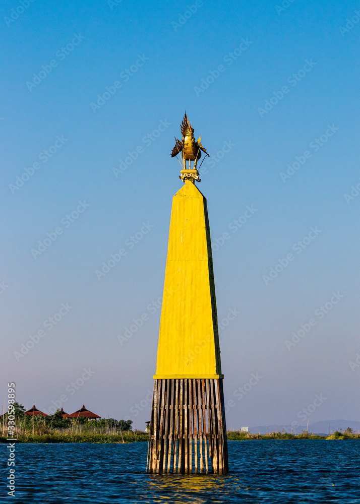 Gold-coloured obelisk with symbolic sculpture of Hintha bird on top in ...