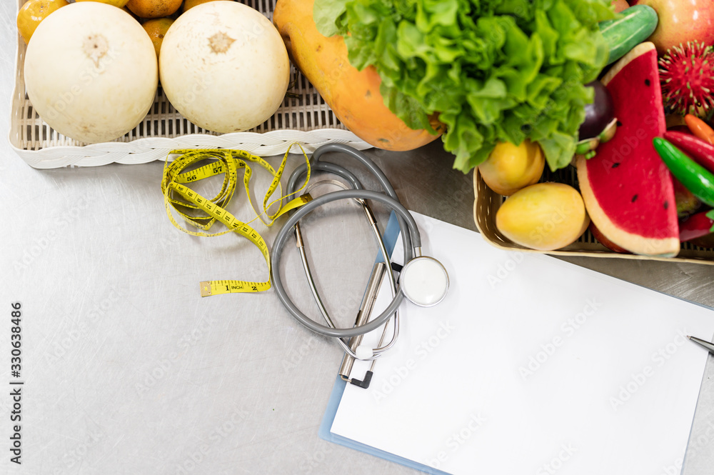 Fruits, vegetables, stethoscope, white paper note chart and yellow ...