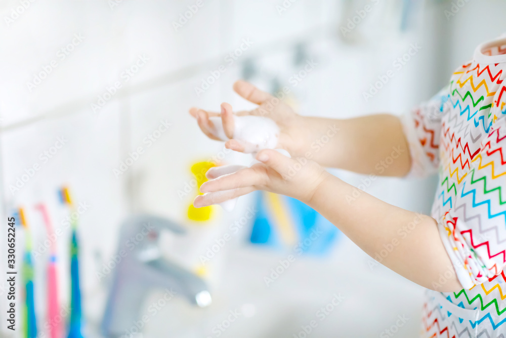 Closeup of little toddler girl washing hands with soap and water in ...