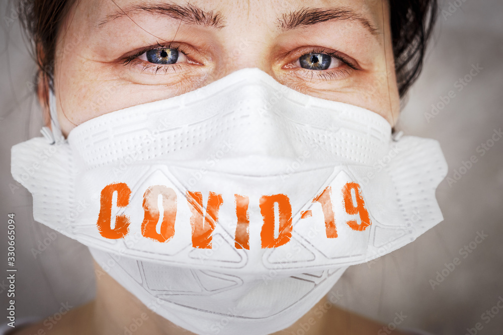 Women with safety mask from virus. Word "COVID-19" written on a mask ...