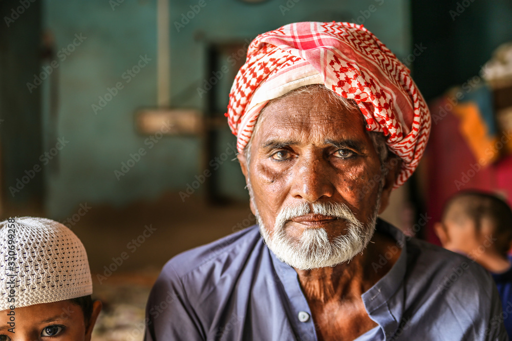 a depressed homeless refugee Arab grandfather wearing traditional ...