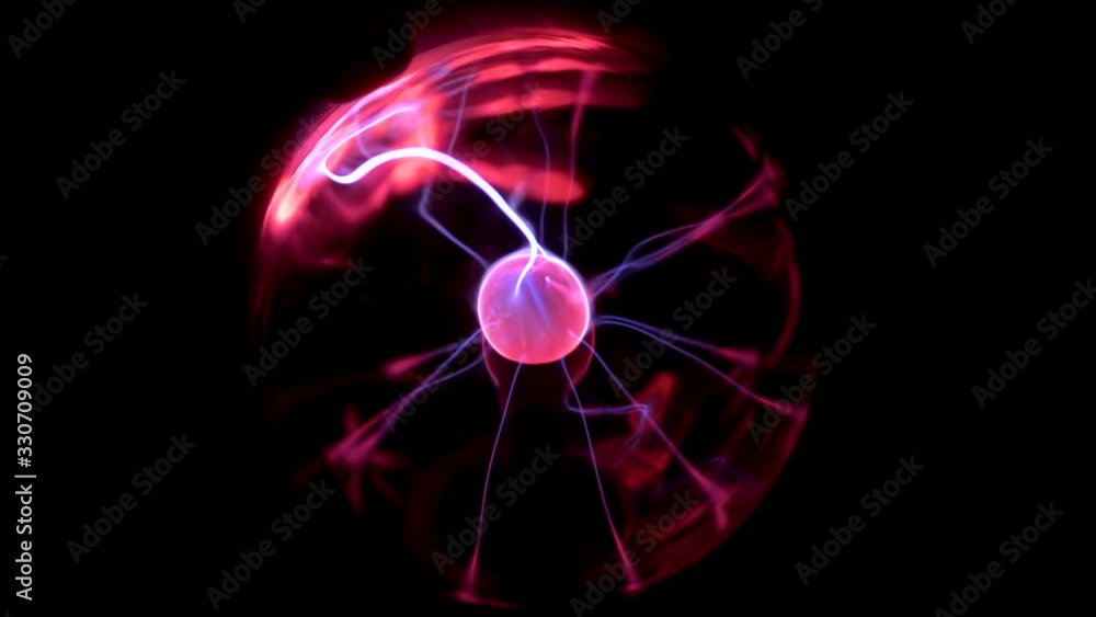 A female hand touches a plasma ball giving out small lightning bolts ...