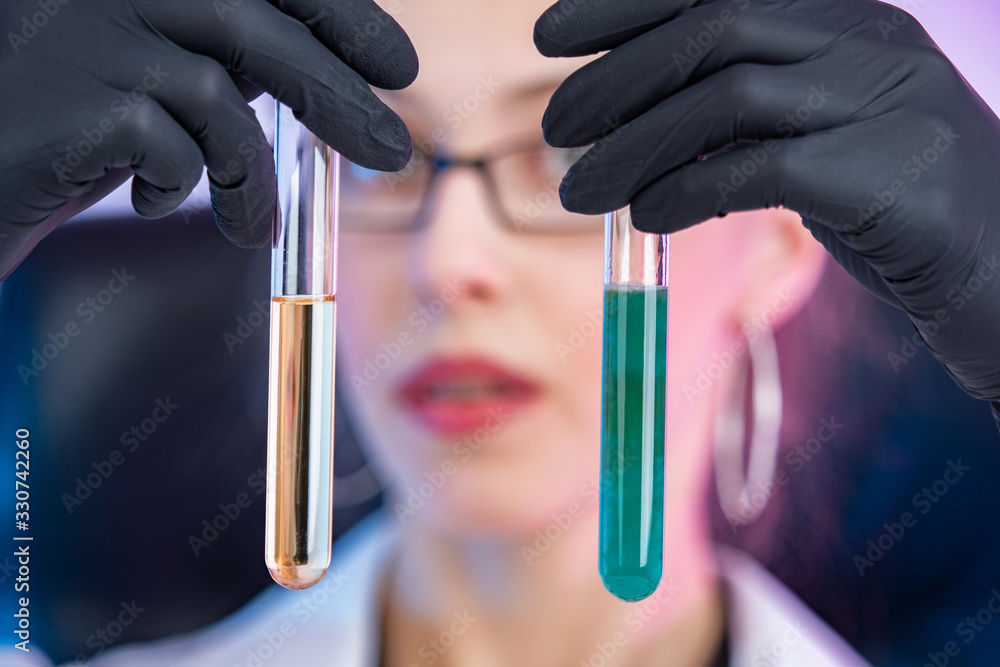 Chemist's hands in rubber gloves with test tubes. The laboratory ...
