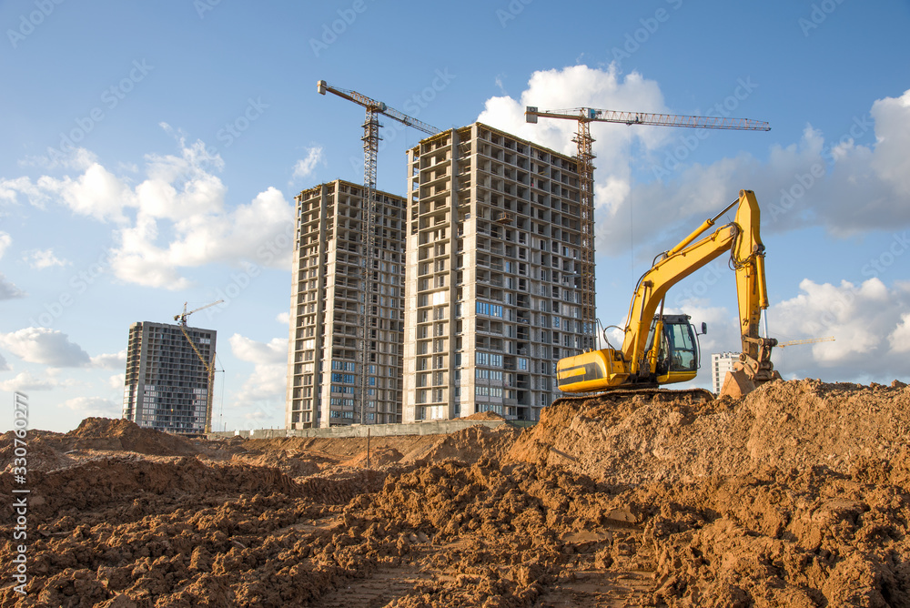 Excavator during Earthmoving Works at construction site. Backhoe digs ...