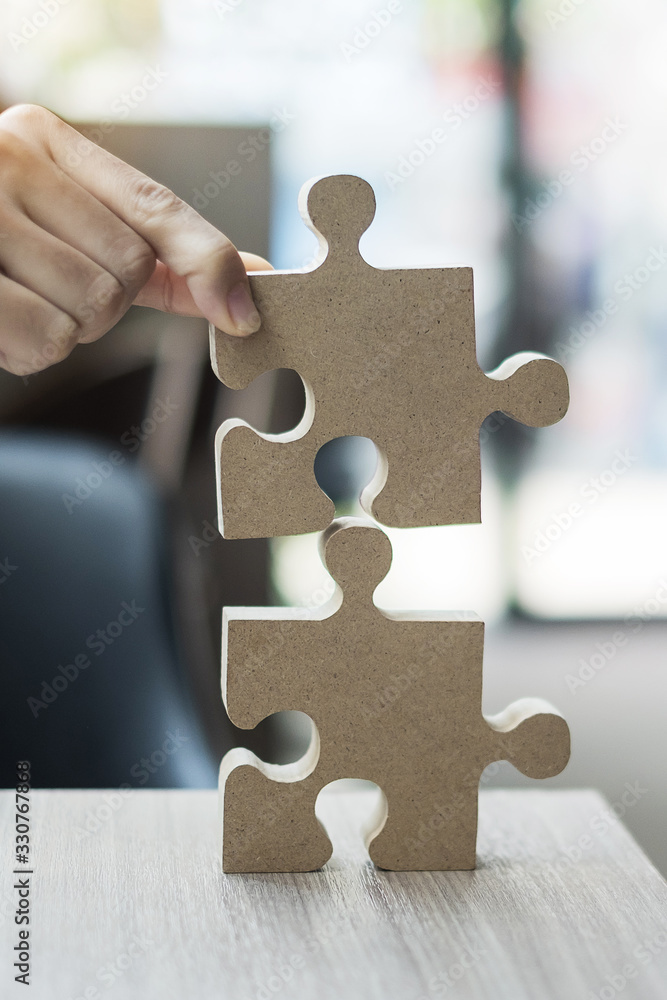 Foto de man hands connecting couple puzzle over table, businessman ...