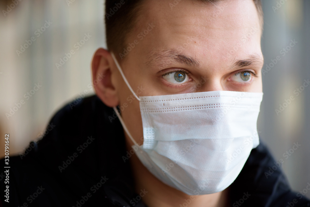 Portrait of a young guy wearing protection face mask against ...