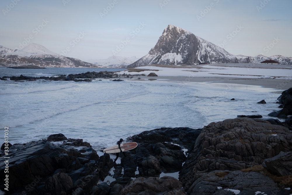 Surfing in cold ocean in Lofoten islands. Famous destination for ...