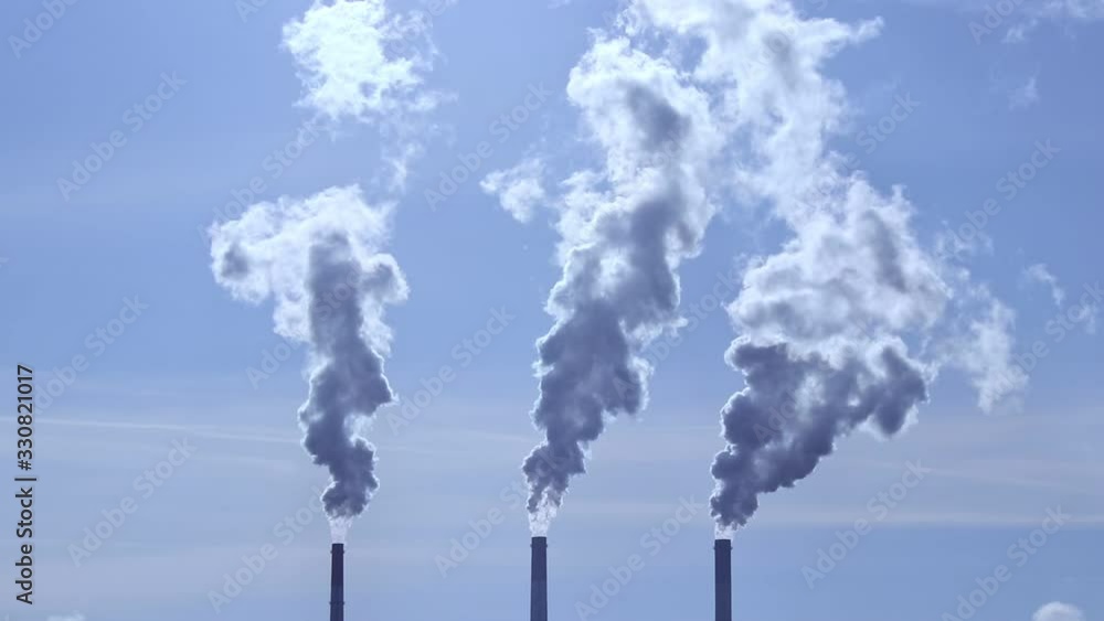Three industrial smoke stacks of big old factory produce terrible smoke ...