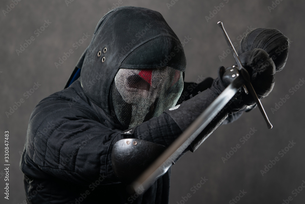 A man in a scary mask with a beard with a skid swords. Historical ...