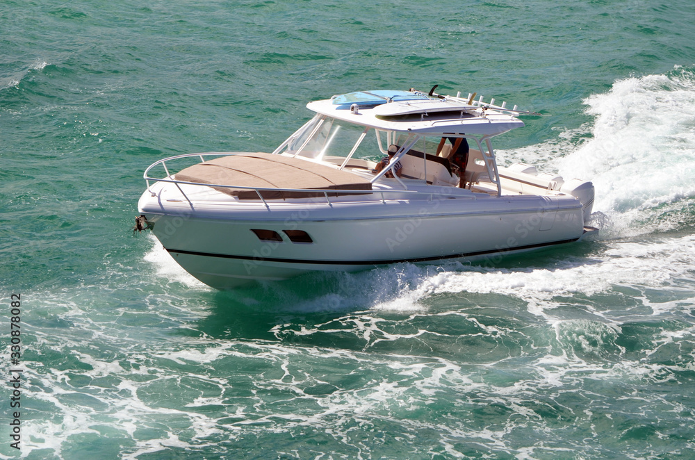 Well appointed small white fishing boat powered by three outboard ...