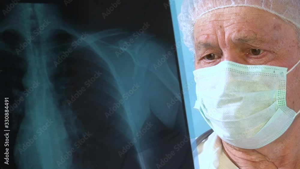 Senior doctor checking chest x-ray film at ward hospital, old caucasian ...