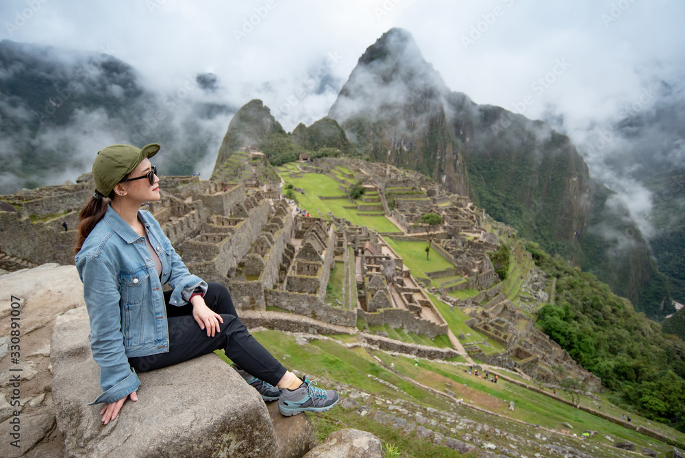 Young Asian woman traveler looking at Machu Picchu, one of seven ...