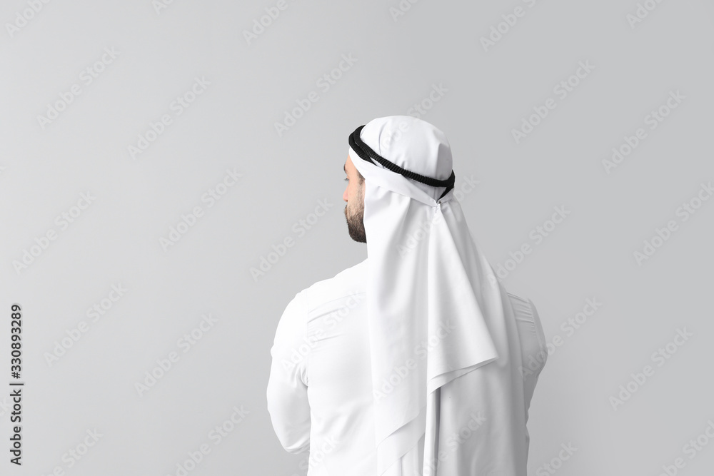 Handsome Arab man on grey background, back view Stock Photo | Adobe Stock