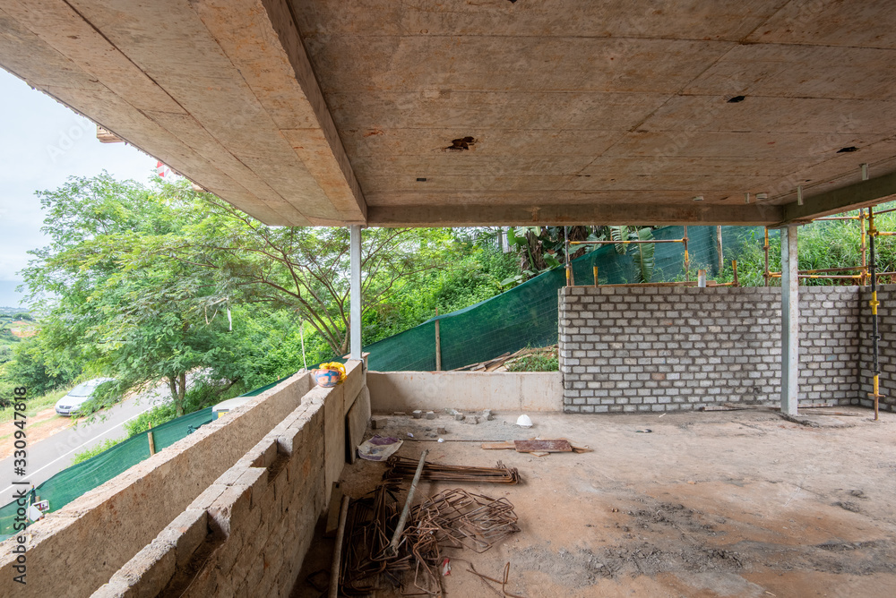 Construction site , large overhang of concrete floor with half built ...