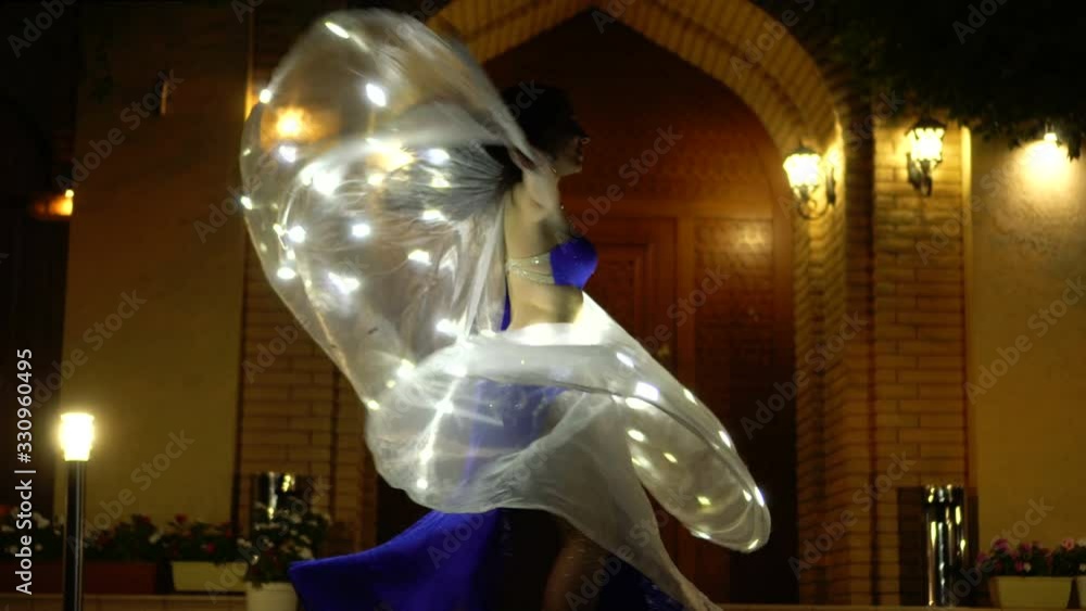 Belly dancer girl dance with two glowing lights wings. Colorful belly ...