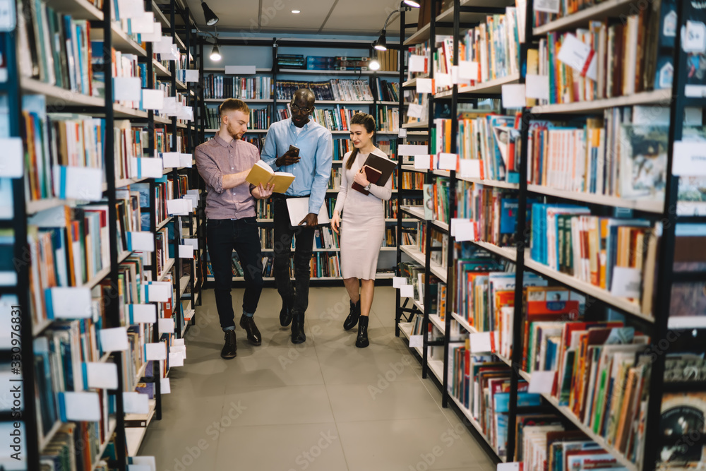 Group of multiracial students walking in library Stock Photo | Adobe Stock