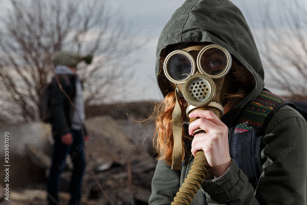 Human in gas mask among ruins and dramatic sky background. Enviromental ...