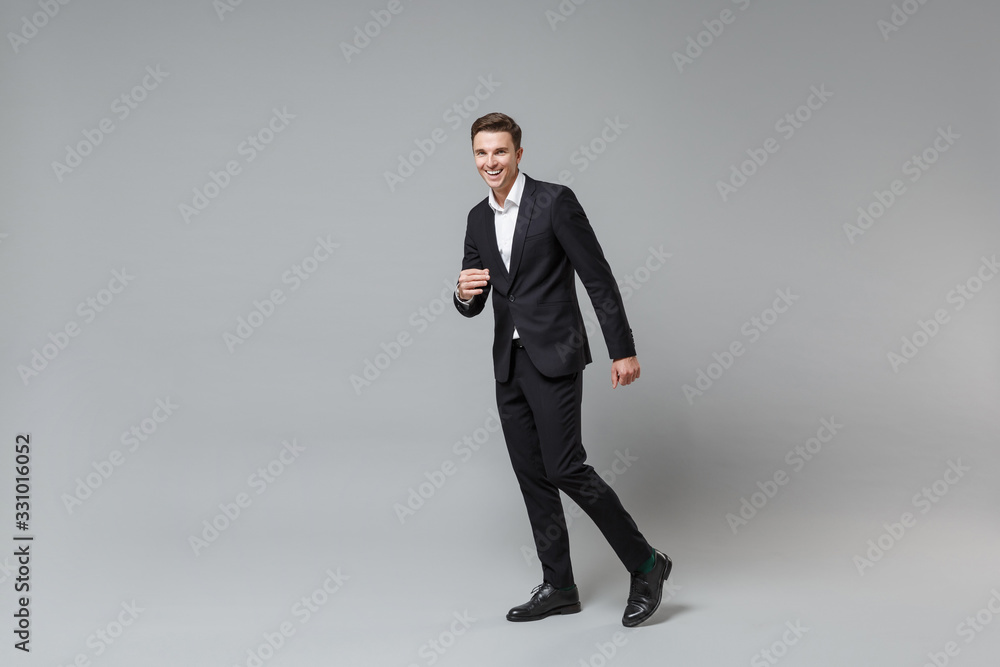 Side view of laughing young business man in classic black suit shirt ...