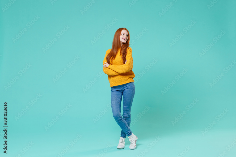 Pretty young redhead woman girl in yellow sweater posing isolated on ...